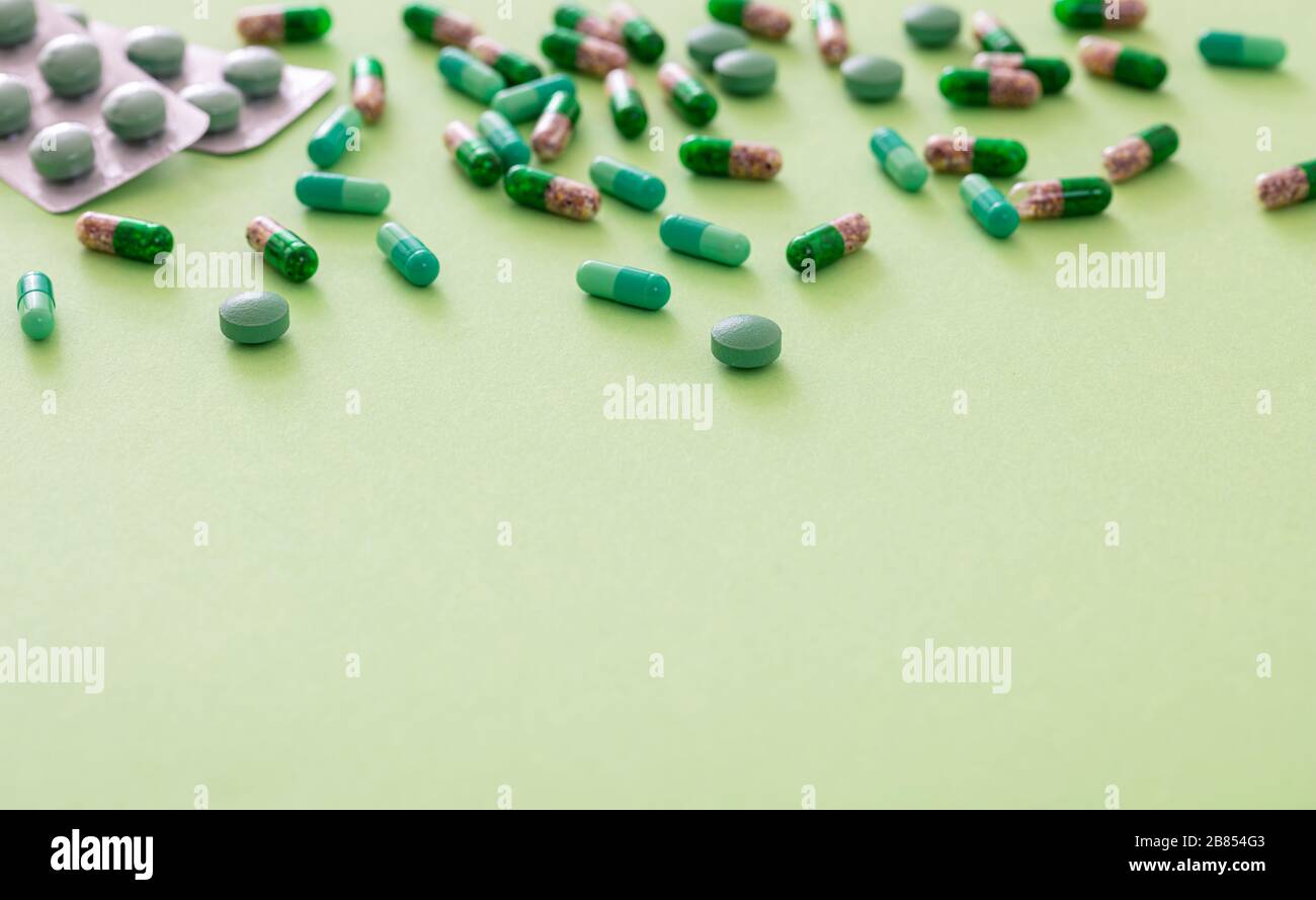 Medicine pills and capsules on light green background. Variation of ...