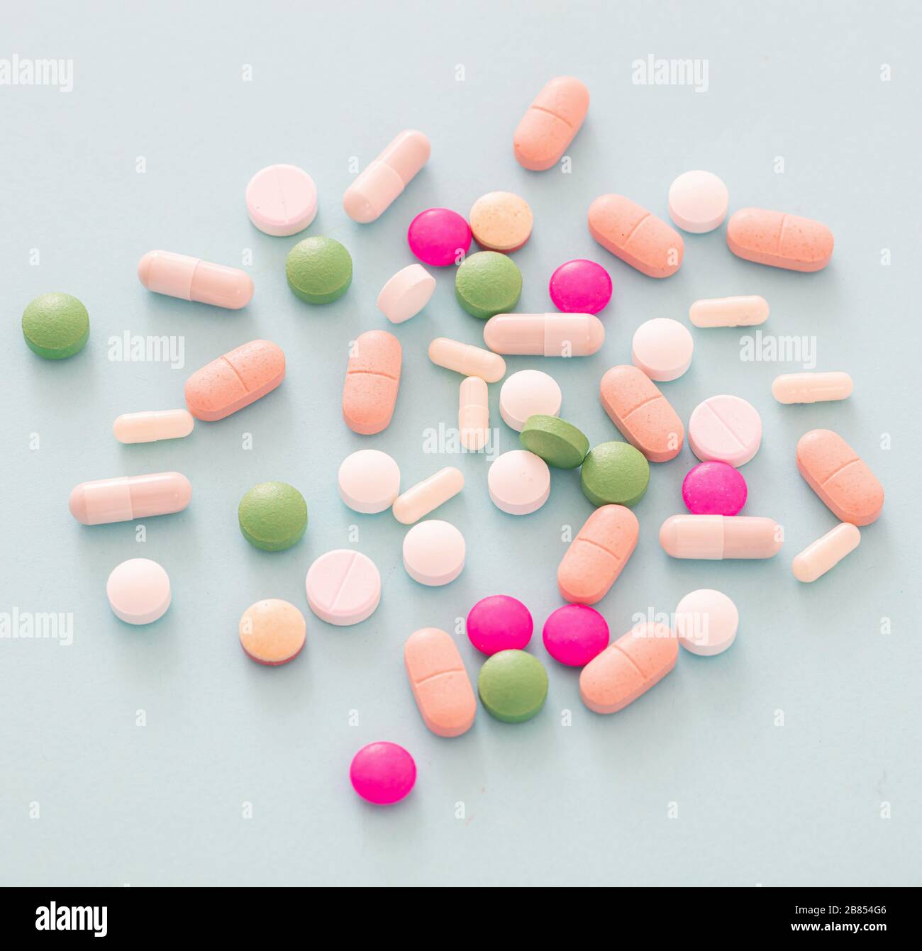 Medicine pills, tablets and capsules on blue pastel background ...