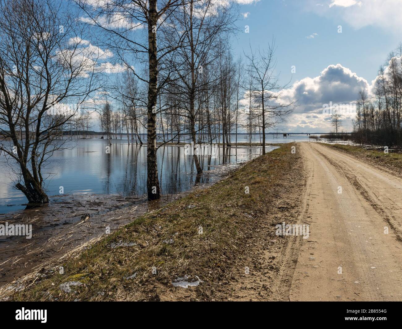 landscape with a flooded lake in spring, the path to the beach ends in ...