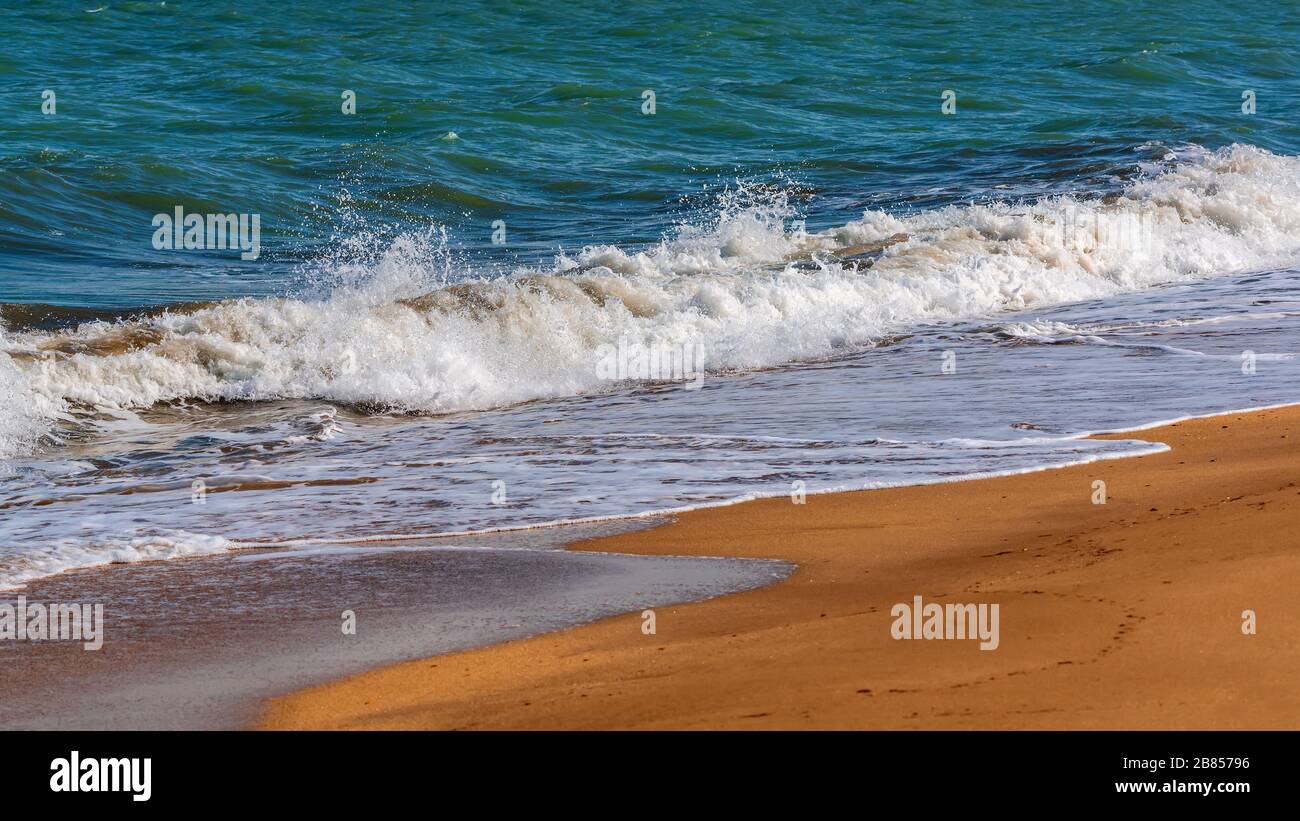 Splashing big waves on sandy beach Stock Photo - Alamy