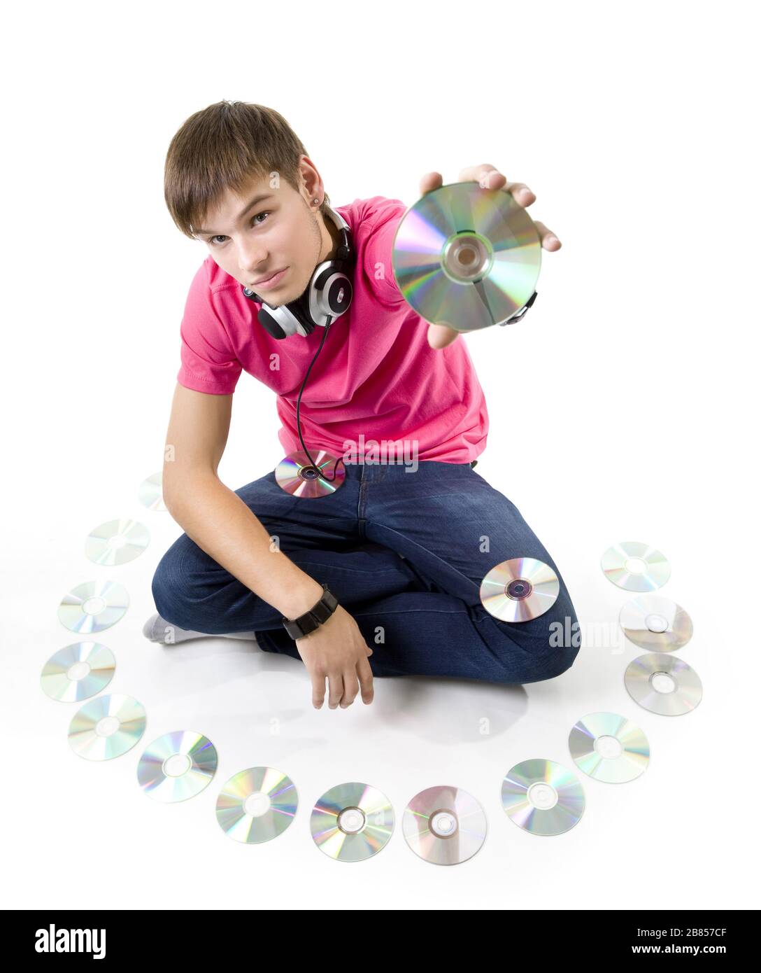 Handsome young man in casual clothes and headphones holds CD in his ...