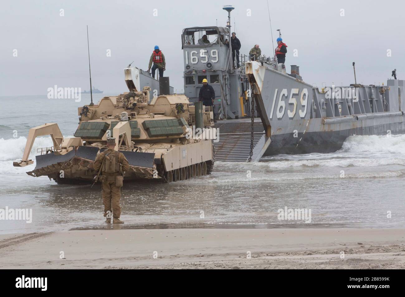 A U.S. Marine Corps M1150 Assault Breacher Vehicle enters a U.S. Navy ...