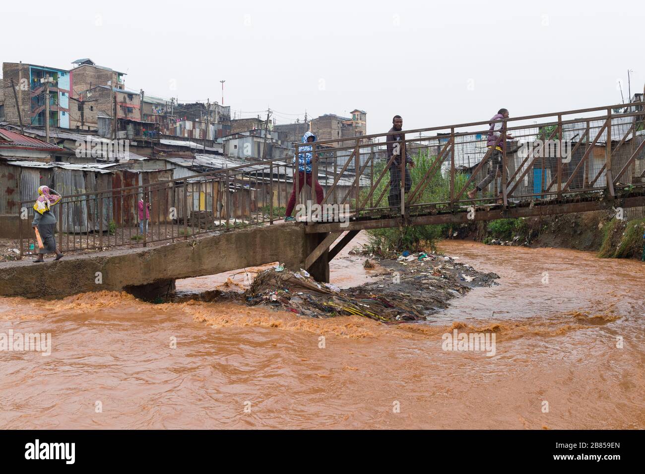 People using a footbridge to cross the Mathare river, Mathare, Nairobi ...