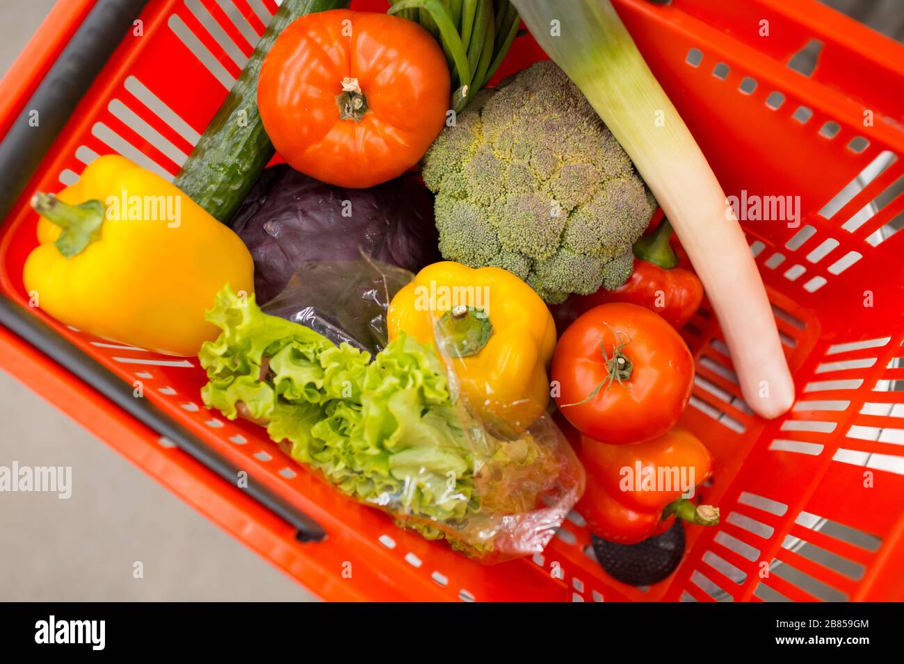 Basket red color with vegetables and herbs in the store. Pepper ...