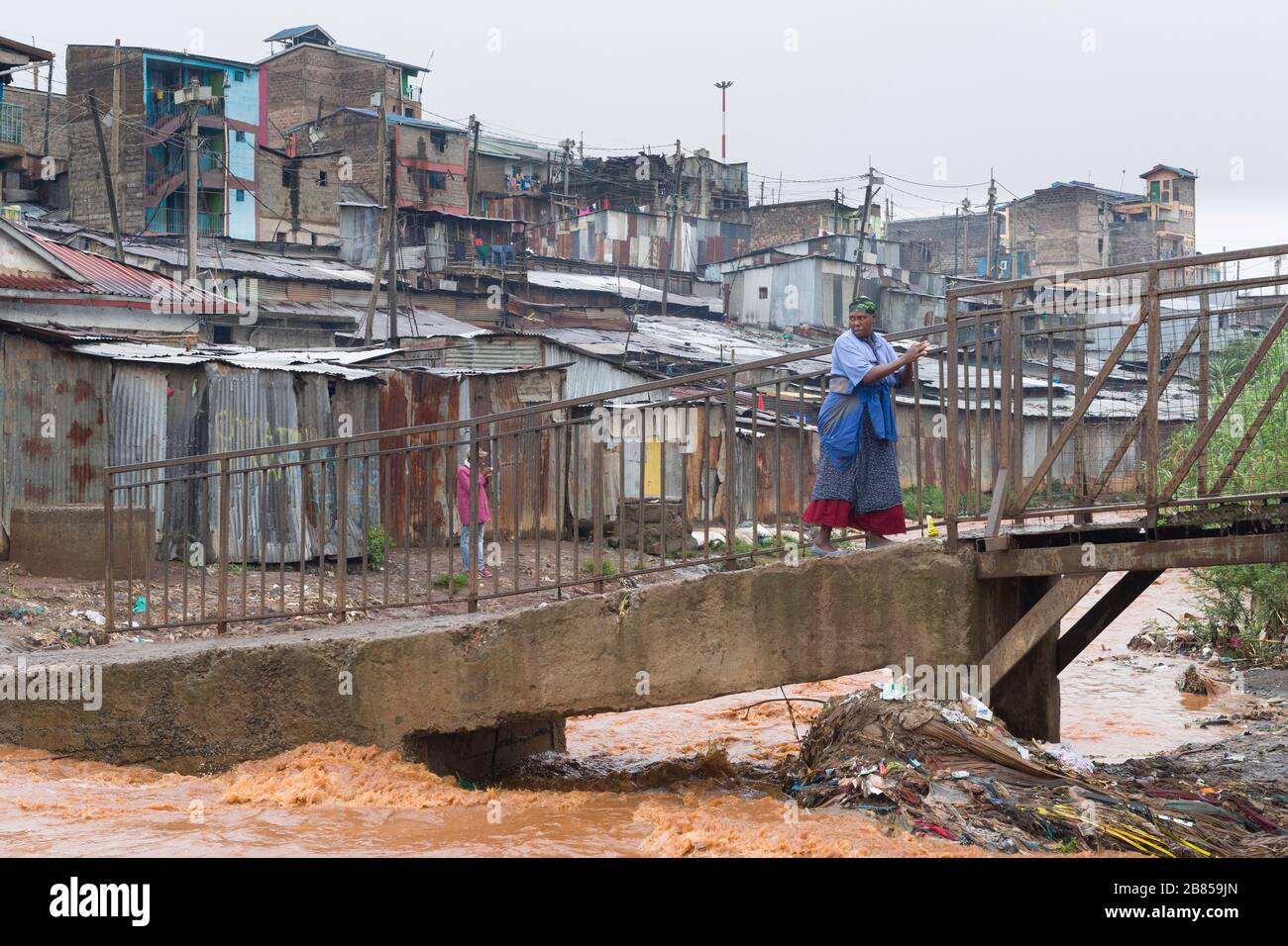 People using a footbridge to cross the Mathare river, Mathare, Nairobi ...