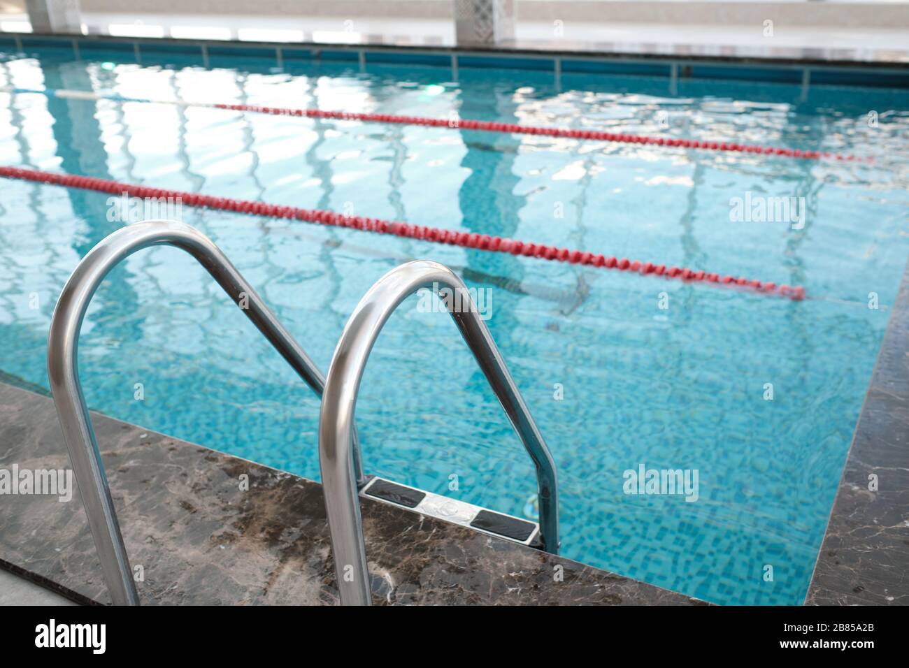 Close-up of metal pool stair with railing used for entry into swimming ...