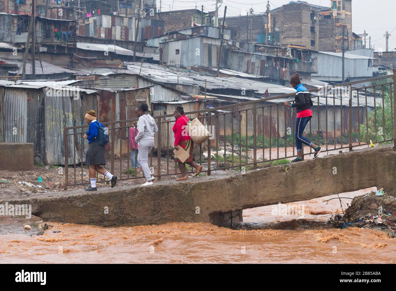 People using a footbridge to cross the Mathare river, Mathare, Nairobi ...