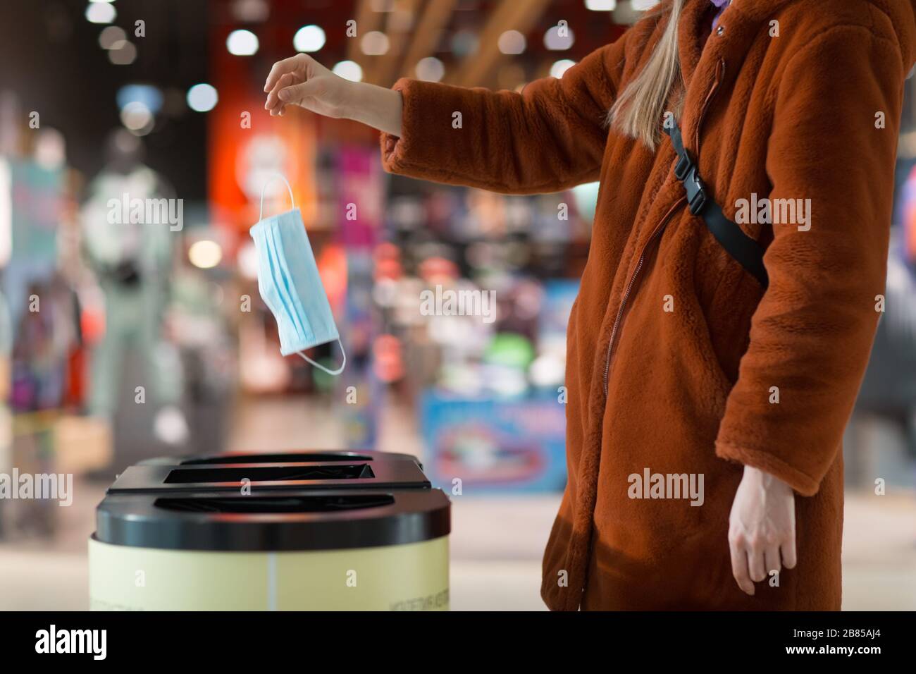 Woman throws a medical mask into the trash Stock Photo - Alamy