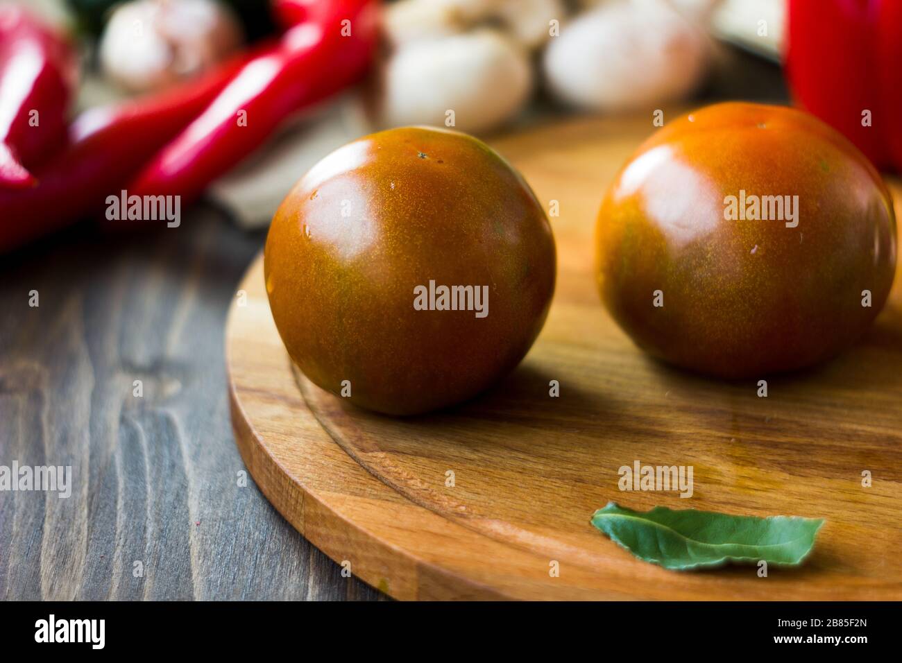 Kumato tomatoes on wooden hi-res stock photography and images - Alamy