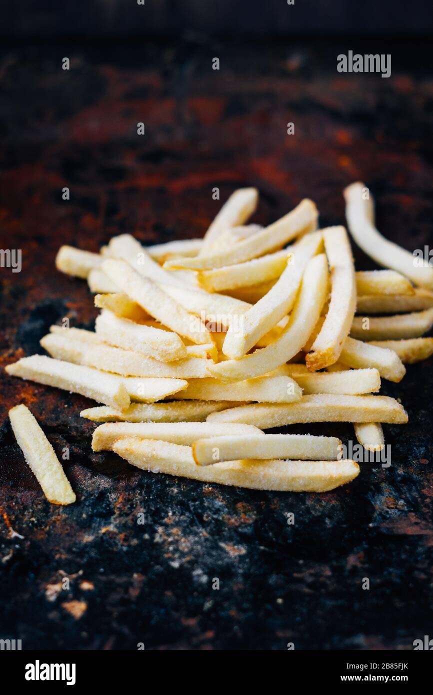 Lot of frozen potatoes fry on black rust background Stock Photo - Alamy
