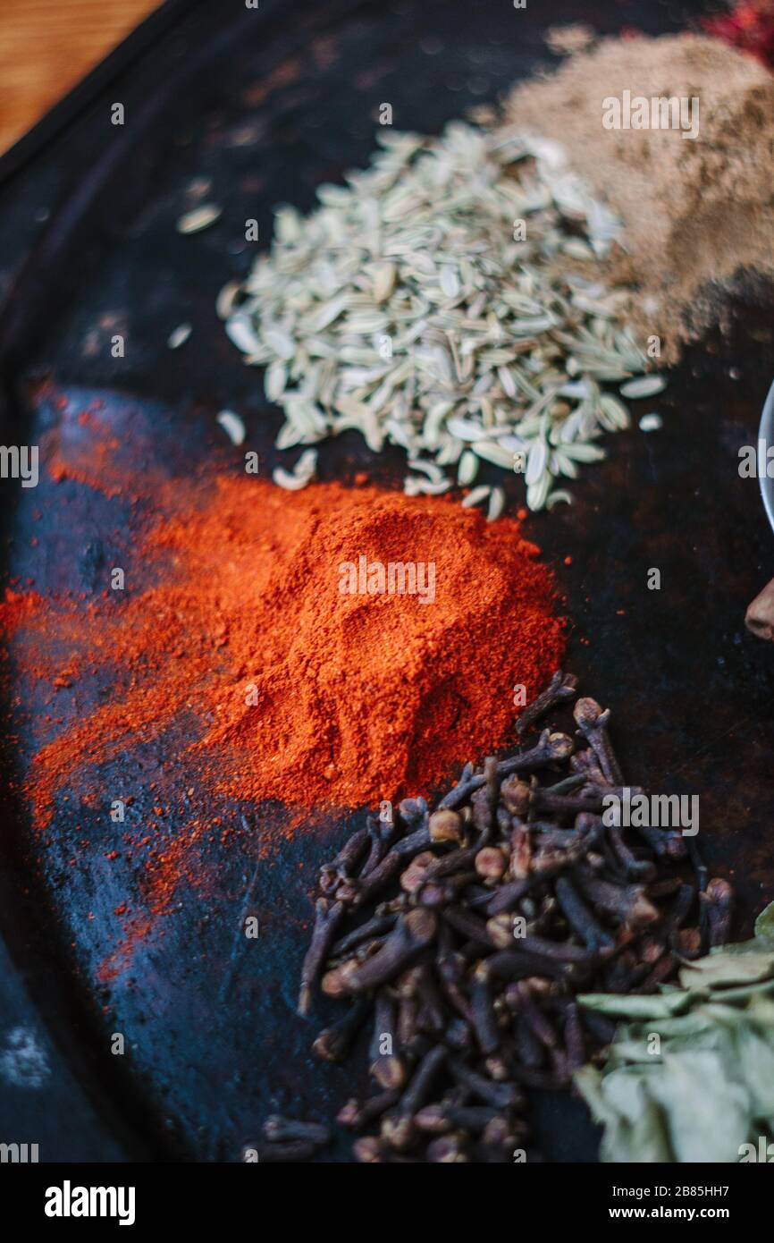 Grounded chili pepper on black rustic surface, surrounded by spices ...