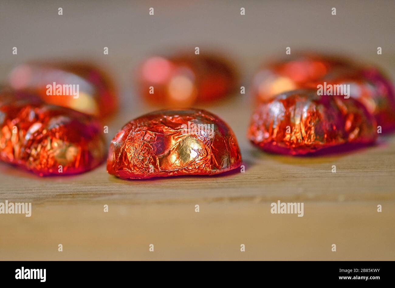 Red chocolate hearts wrapped in red foil for Valentine's Day. Stack of ...