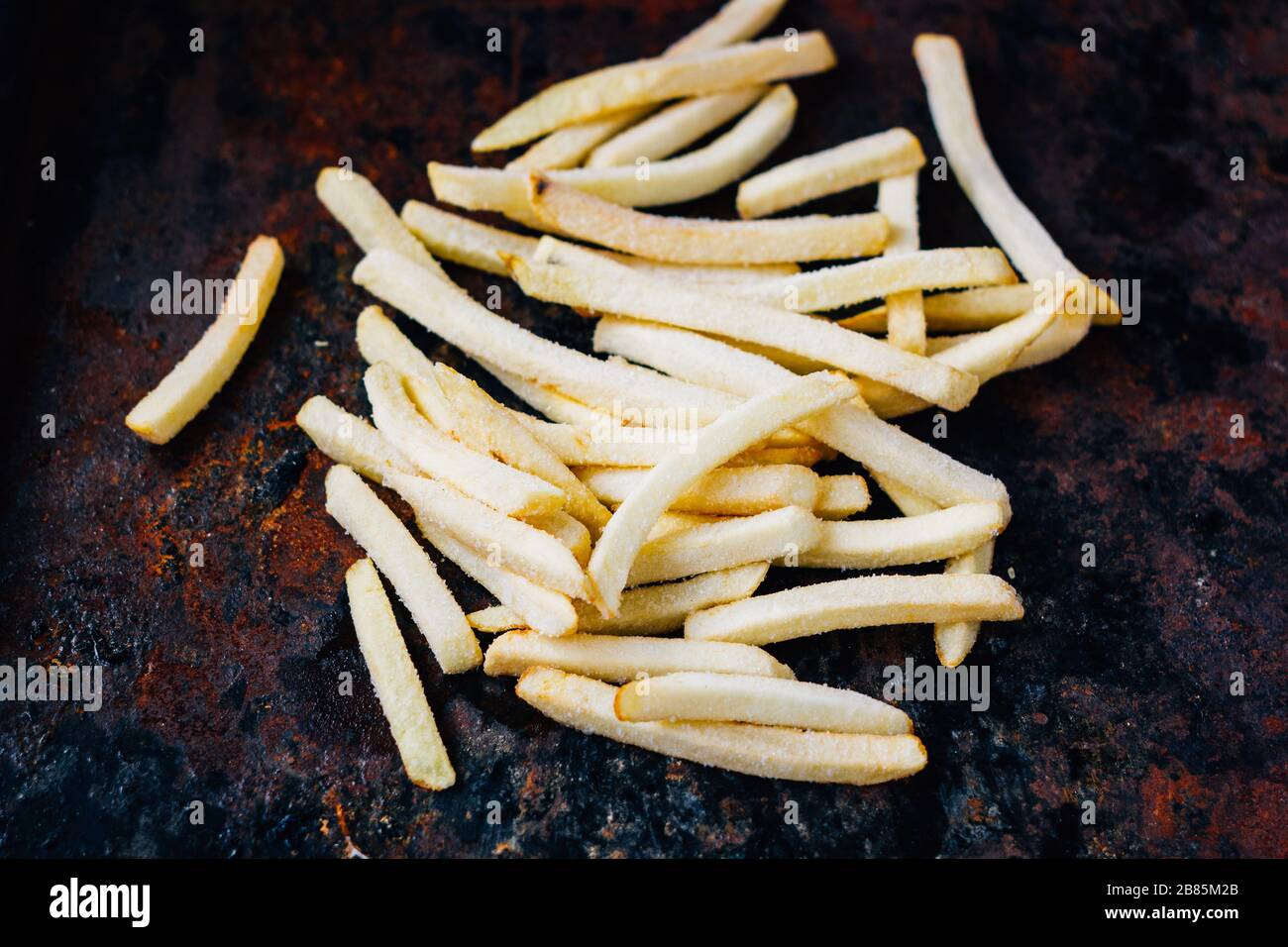 Lot of frozen potatoes fry on black rust background Stock Photo - Alamy