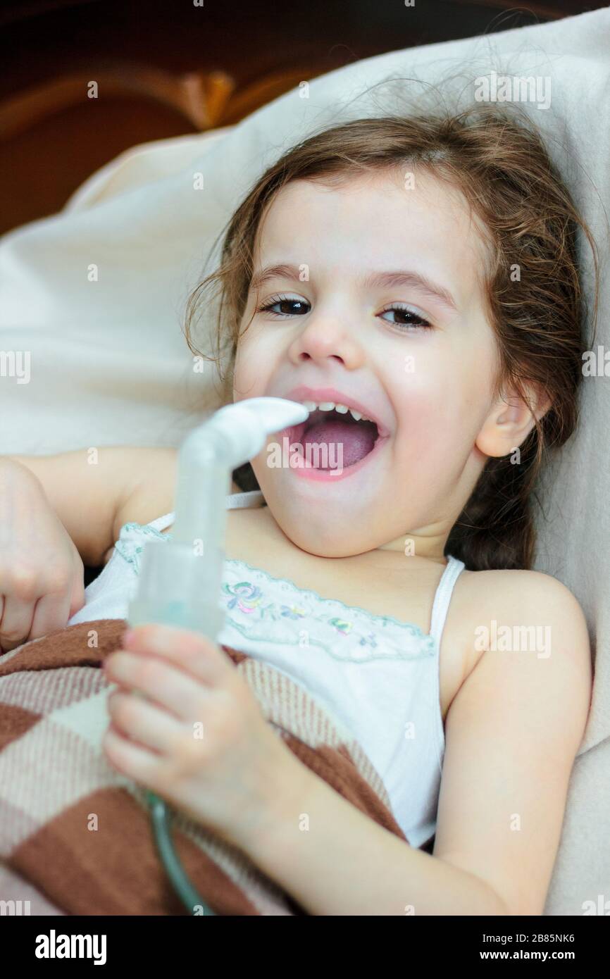 Child with respiratory illness making inhalation with inhaler Stock ...