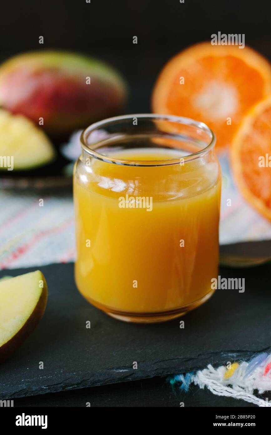 Fresh mango and orange detox drink over black slate Stock Photo - Alamy