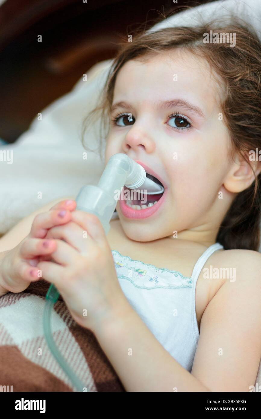 Child with respiratory illness making inhalation with inhaler Stock ...