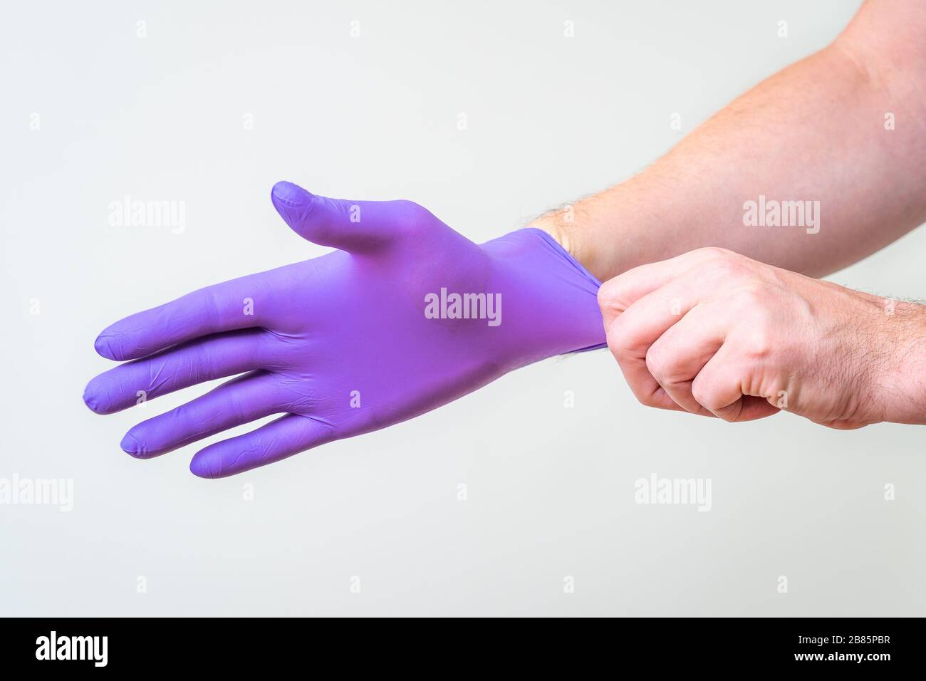 Male hand pulling a glove on Stock Photo - Alamy