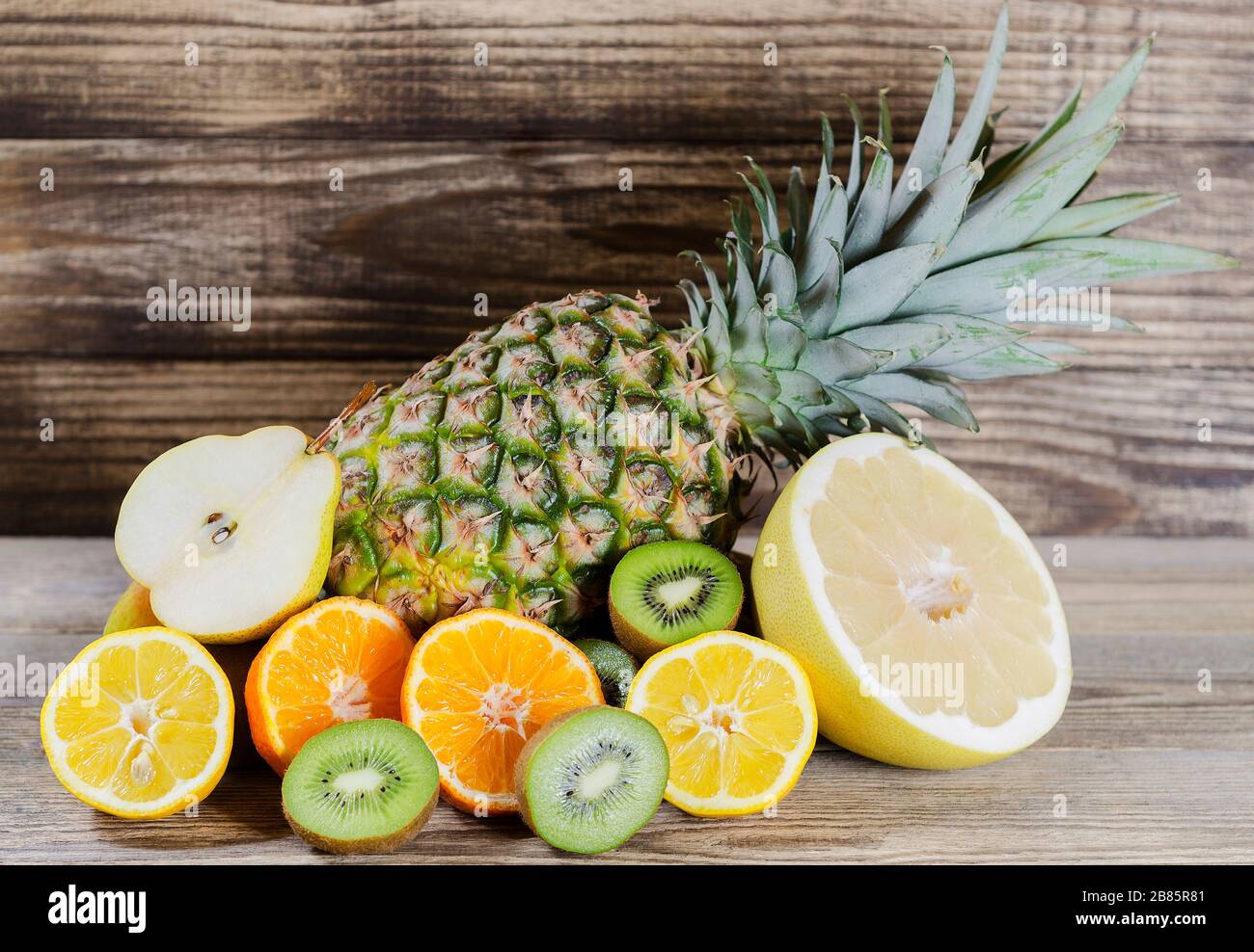 pineapple and sliced lemon, kiwi, pamela and pear piled on a background ...