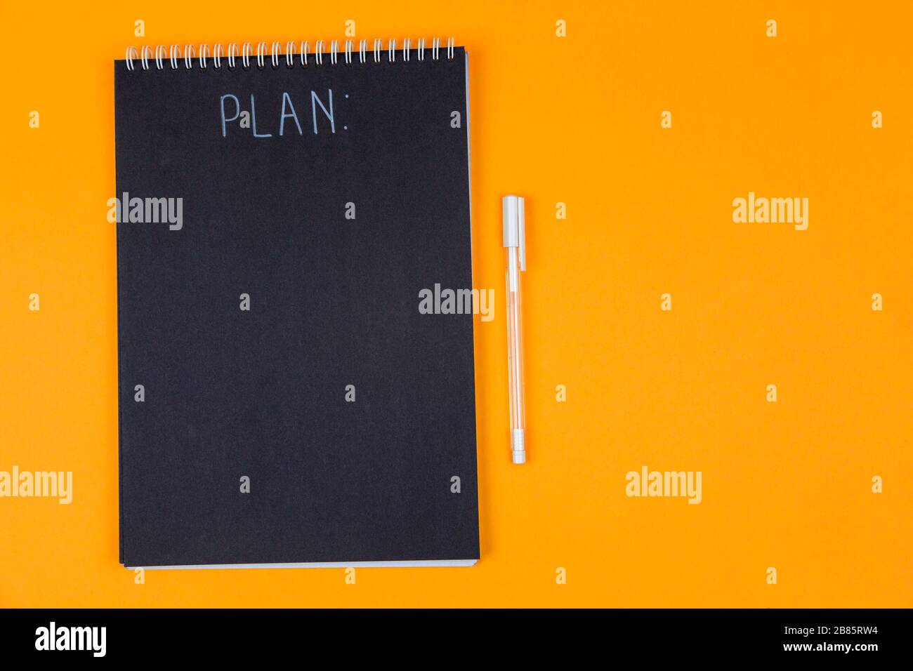 Wide view image of blank black spiral note pad and white marker with ...