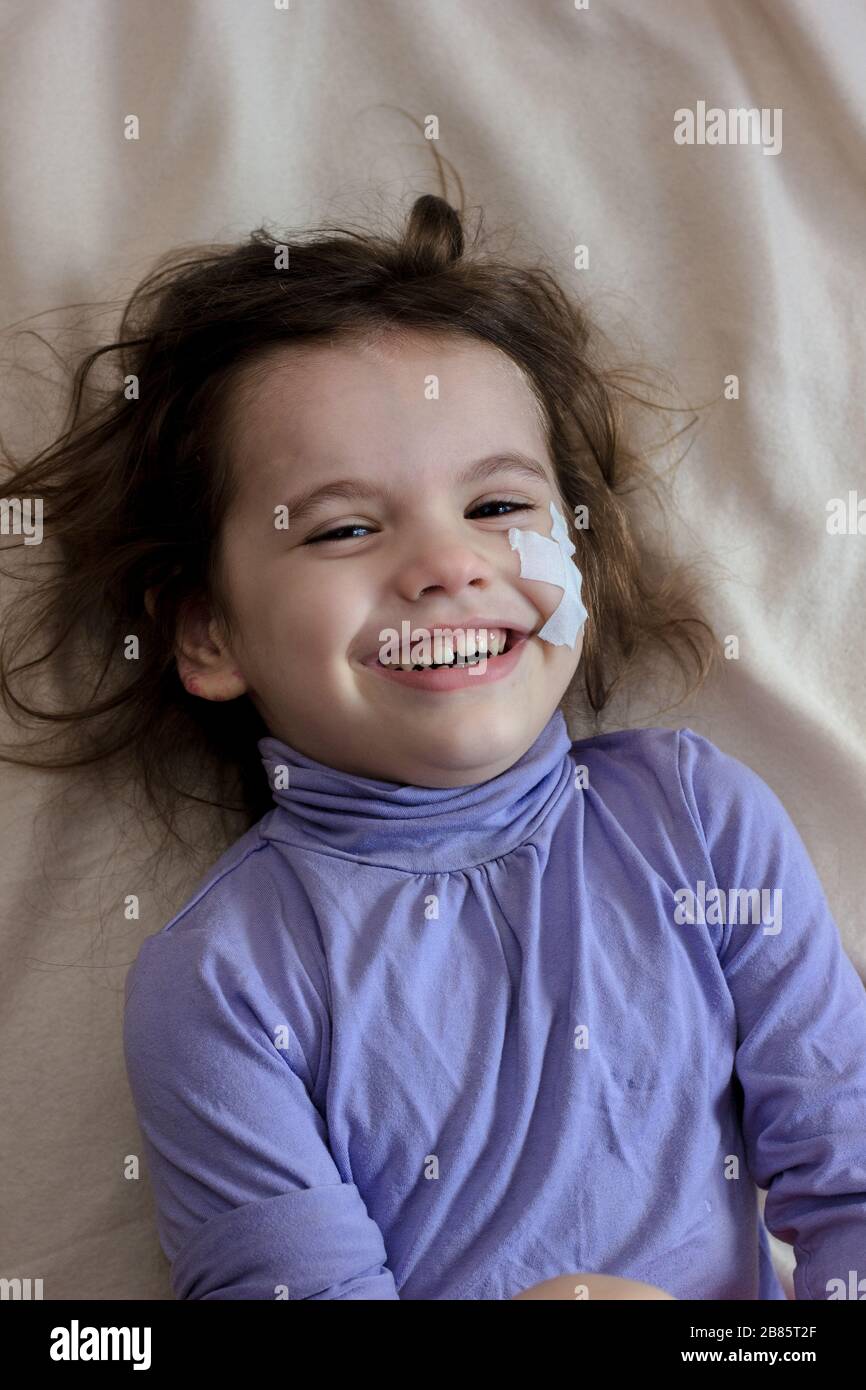 Little kid girl after accident with adhesive band on face laughing ...
