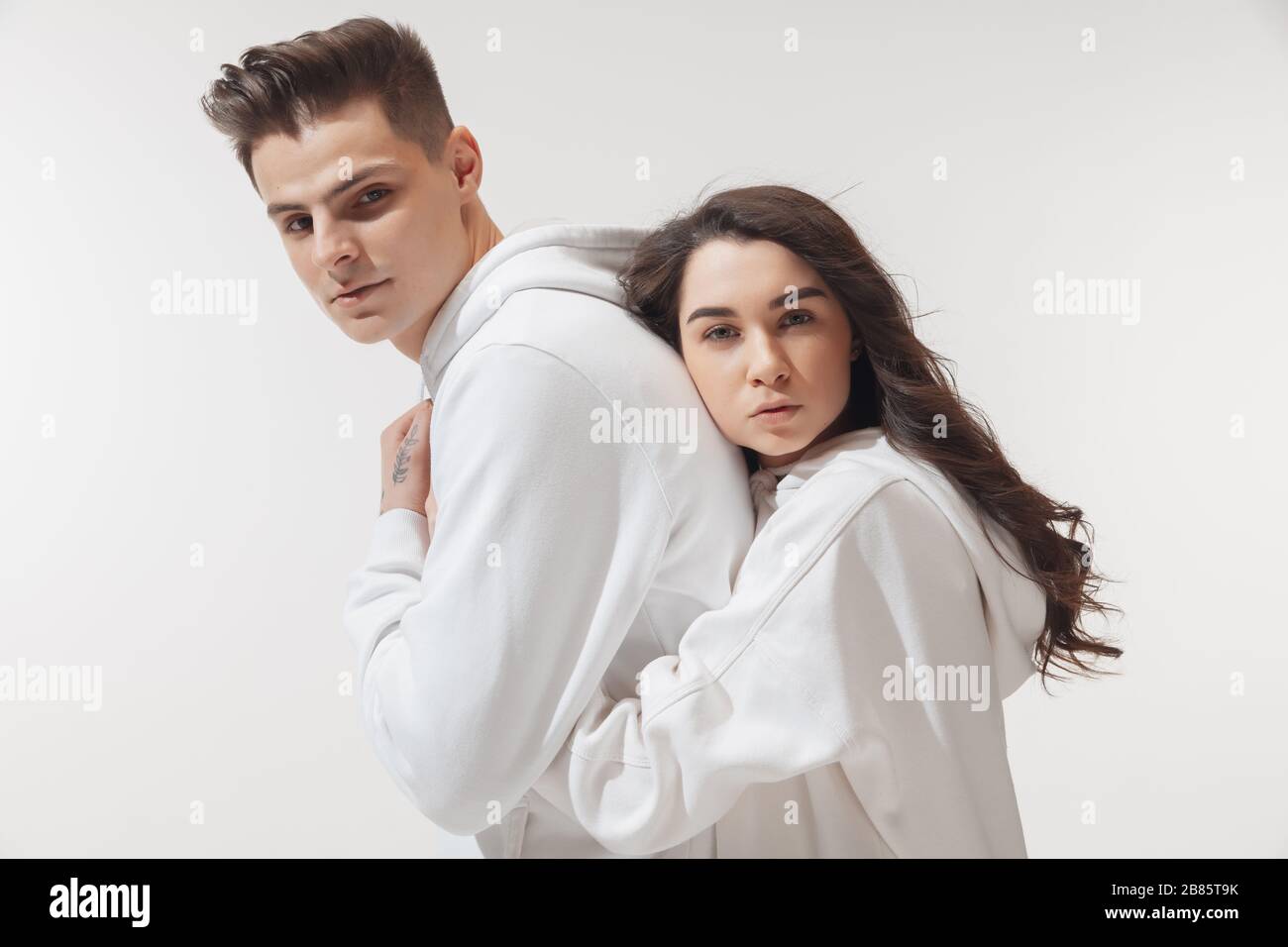 Tender hug. Trendy fashionable couple isolated on white studio ...