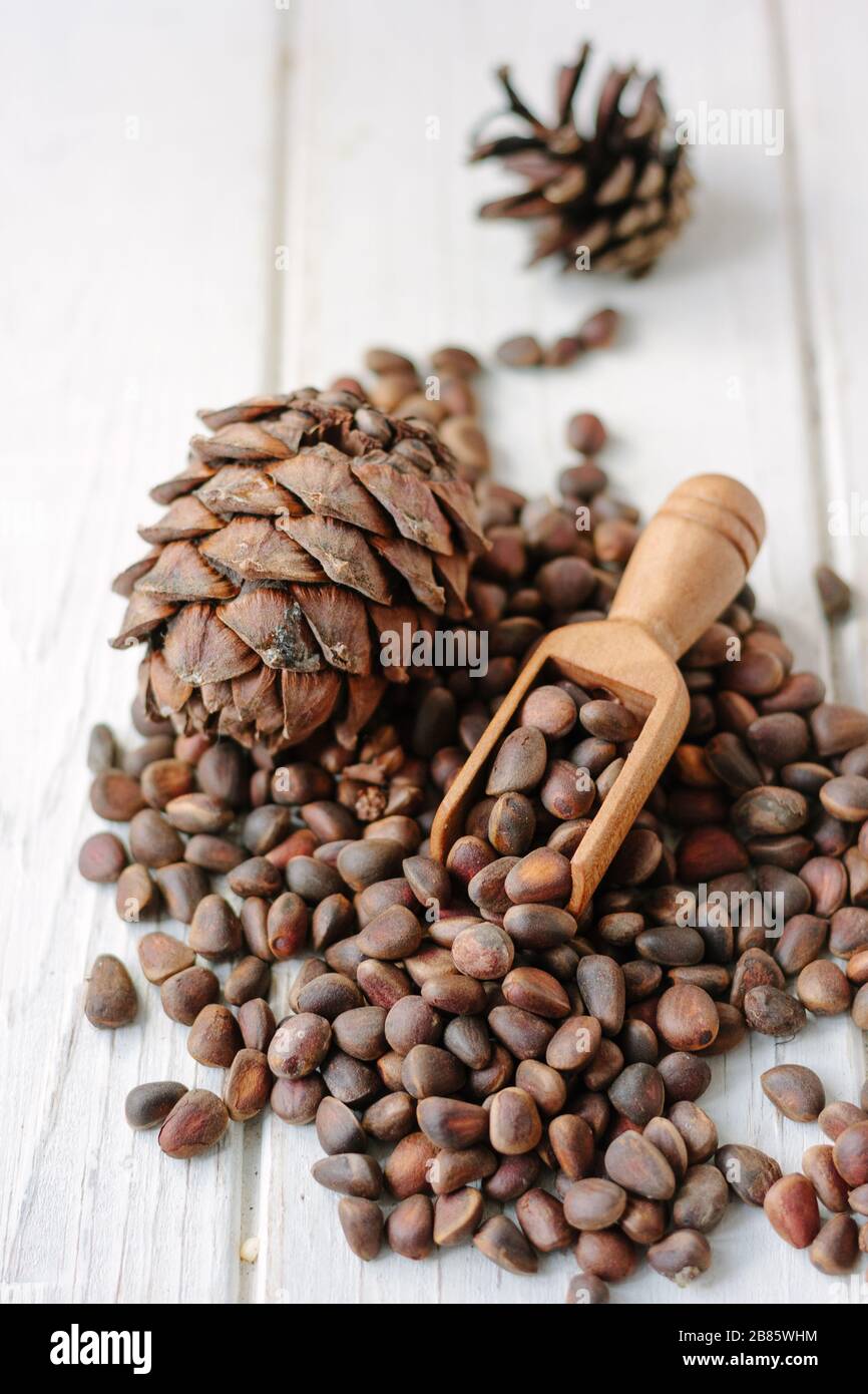 Cedar nuts in wooden scoop over heap of cedar nuts Stock Photo - Alamy