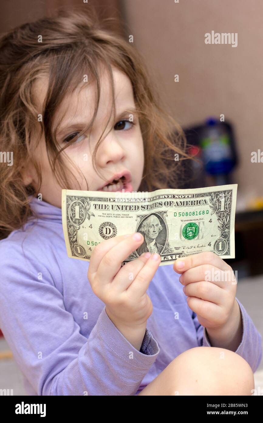 Young kid girl holding money in hands Stock Photo - Alamy