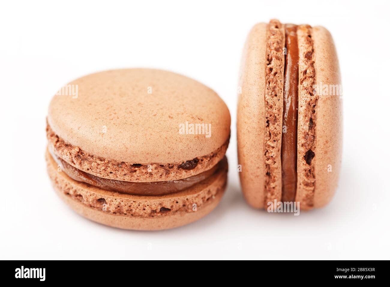 Chocolate macaroni cookies on a white background with brown filling ...