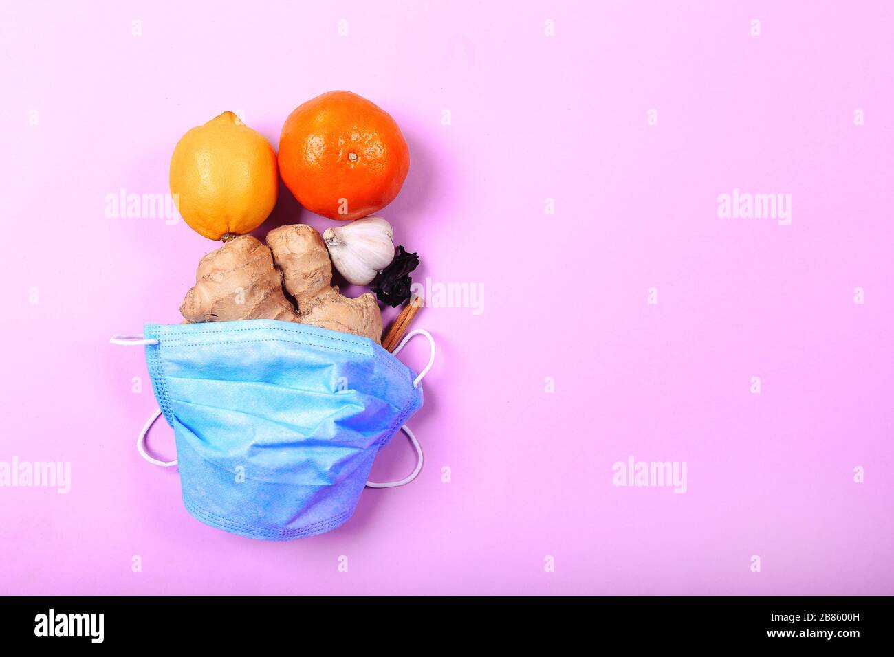 Protective face mask covering food, alternative medicines on pink ...