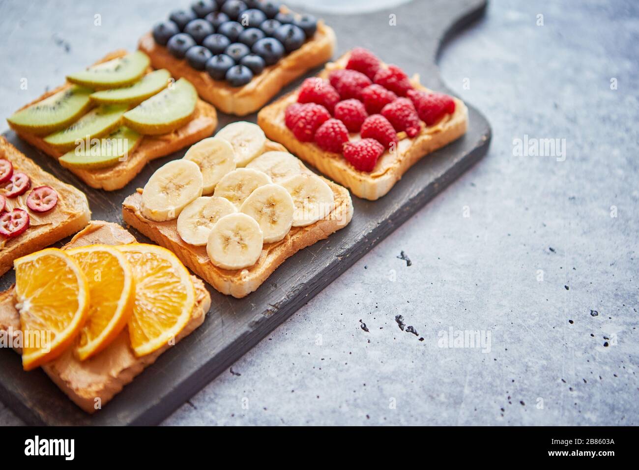 Wholegrain bread slices with peanut butter and various fruits Stock ...