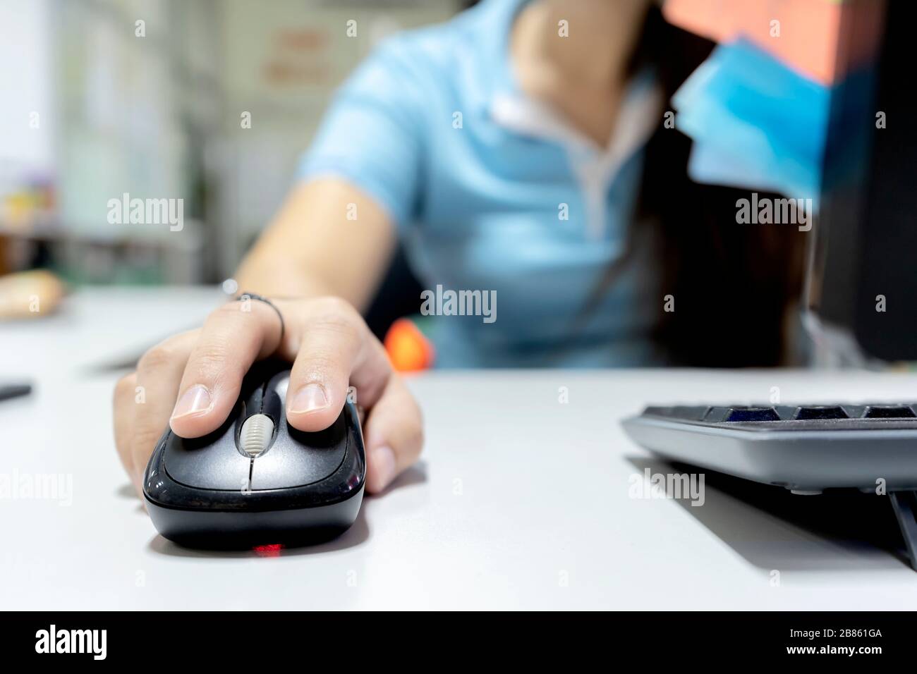Businessmen are working in the office. Her hand is holding the mouse to ...