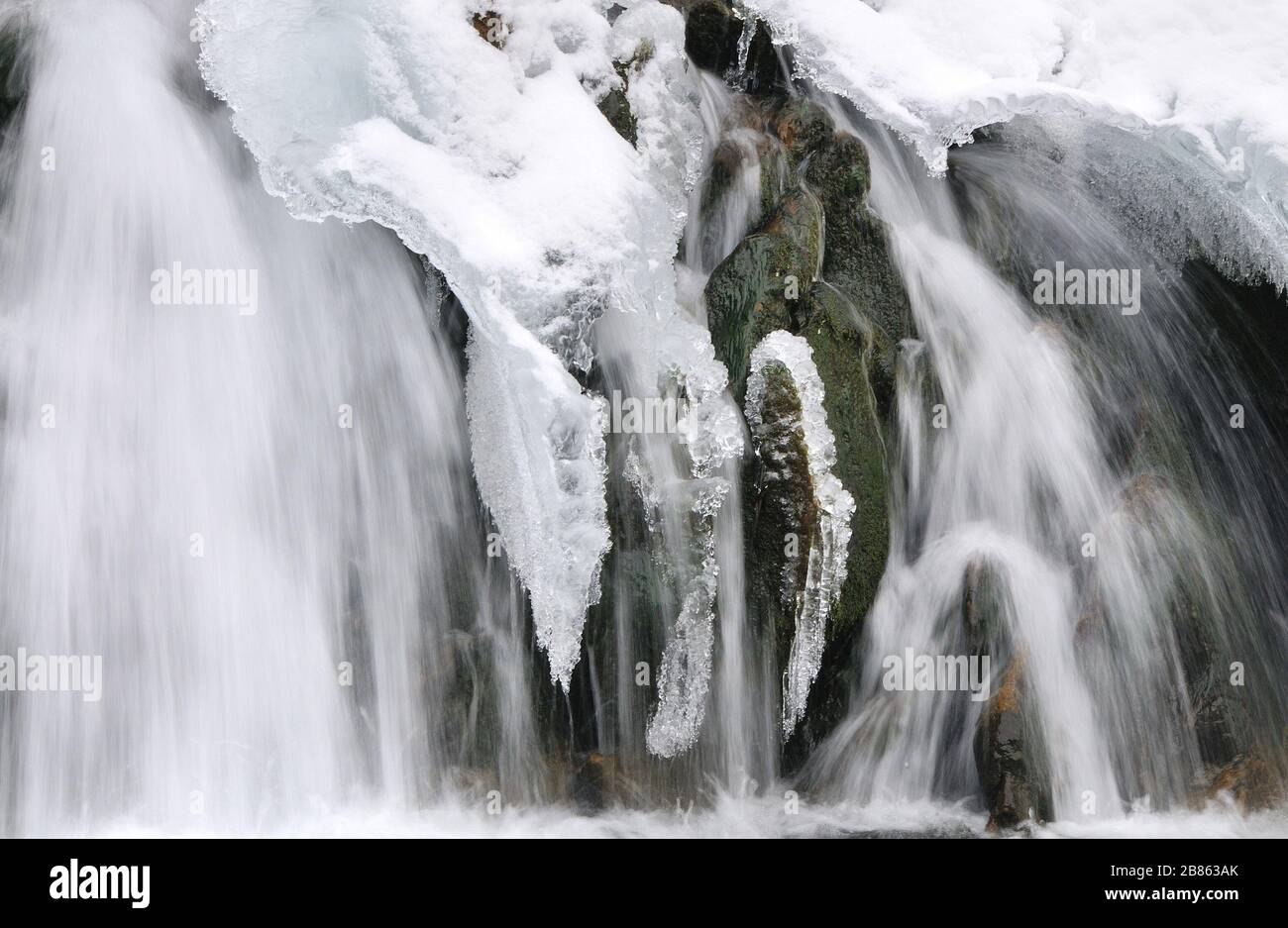 Beautiful snowy waterfall flowing in the mountains. Winter landscape ...