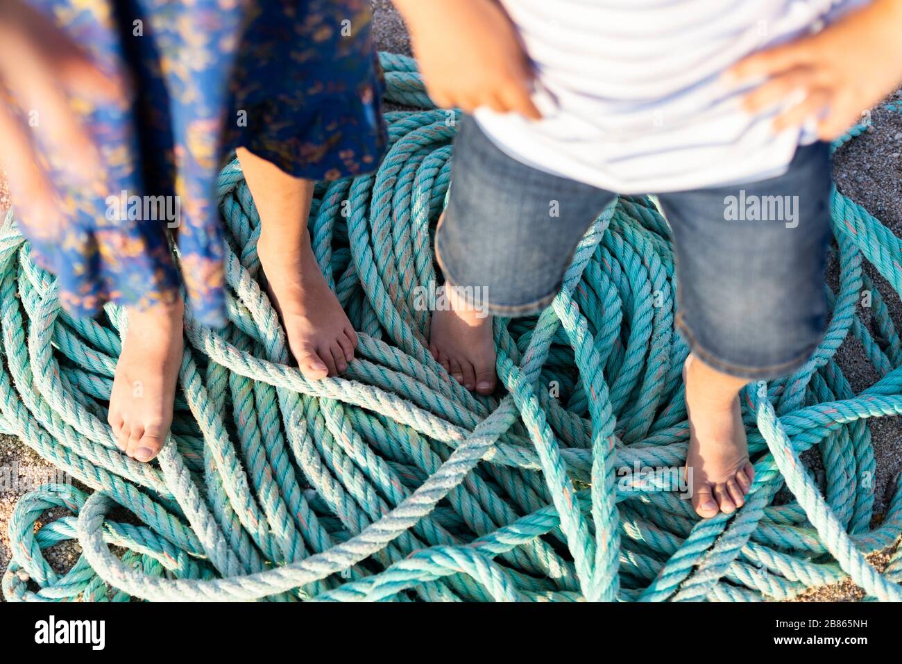 The feet of two children on fishing ropes Stock Photo - Alamy