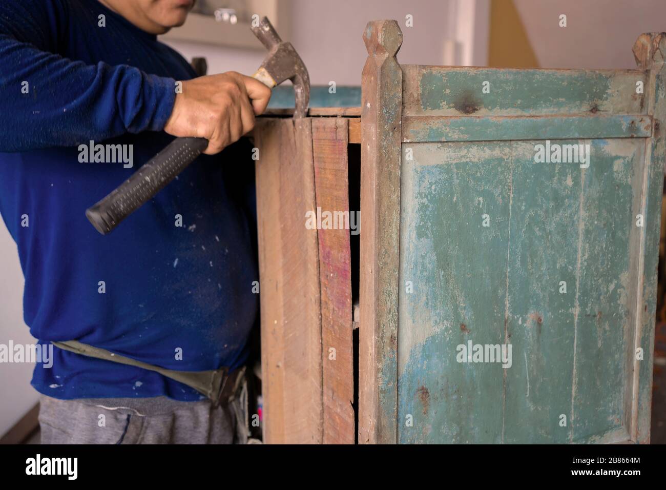 Man building a house and workimg with hammer and wood. Carpenter ...