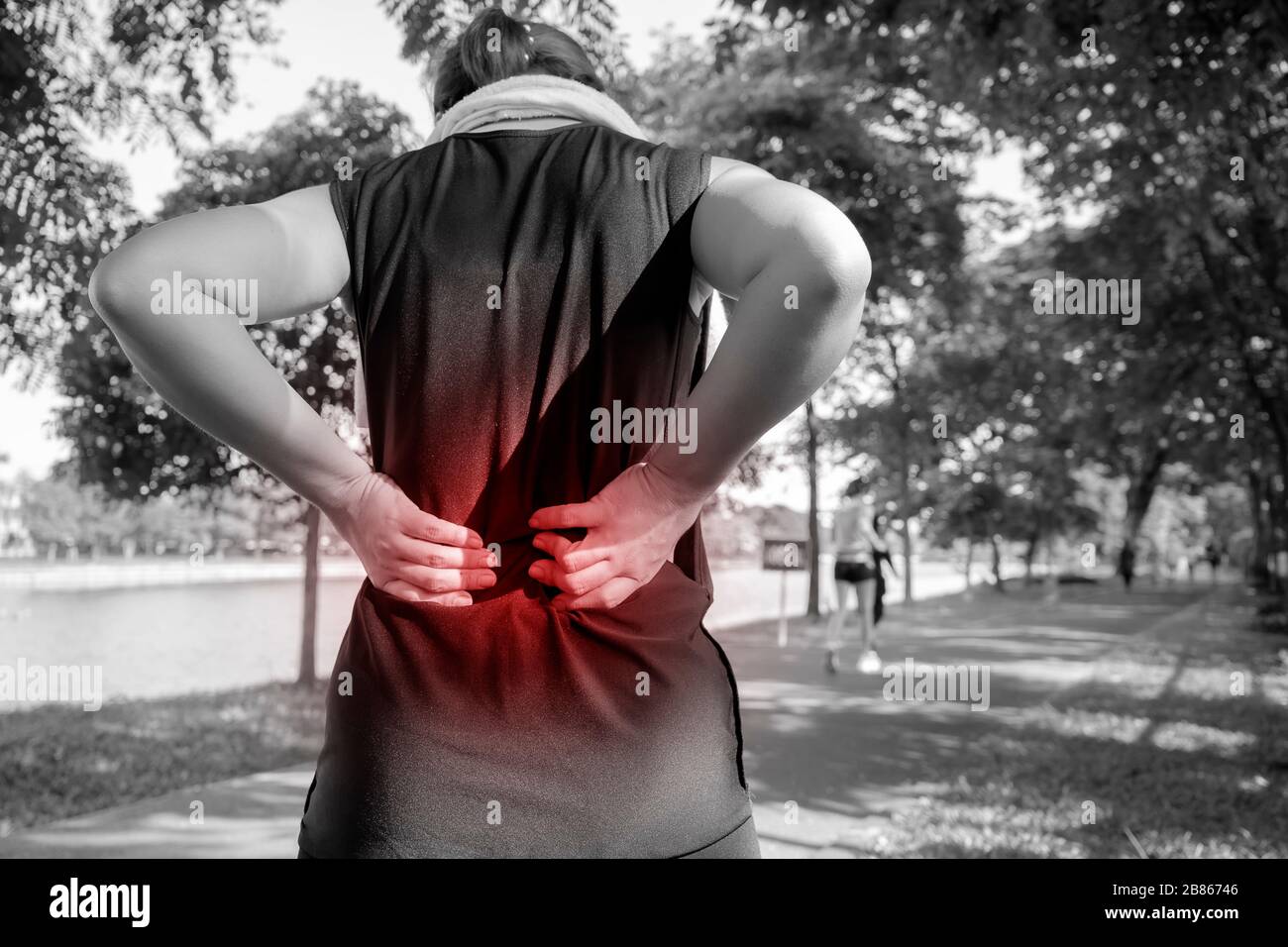 Back pain concept. touches the lower back muscle that stands on the ...