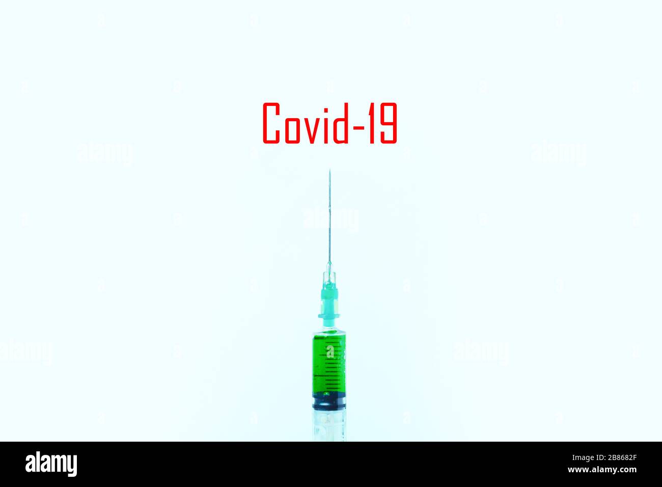 green liquid in a syringe on a blue background, concept of Covid-19l ...
