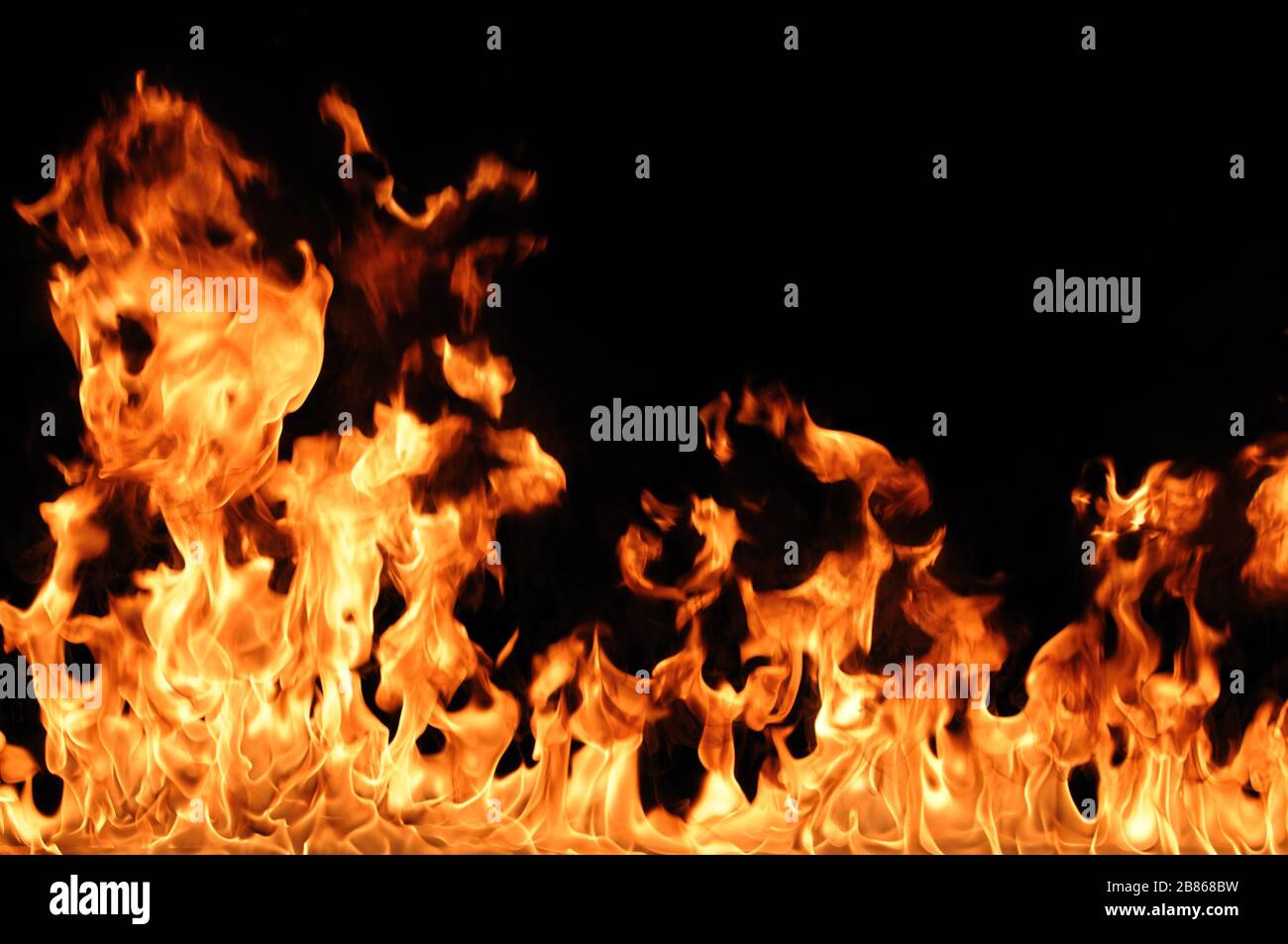 Abstract orange warm fire burns on isolated dark background close-up ...