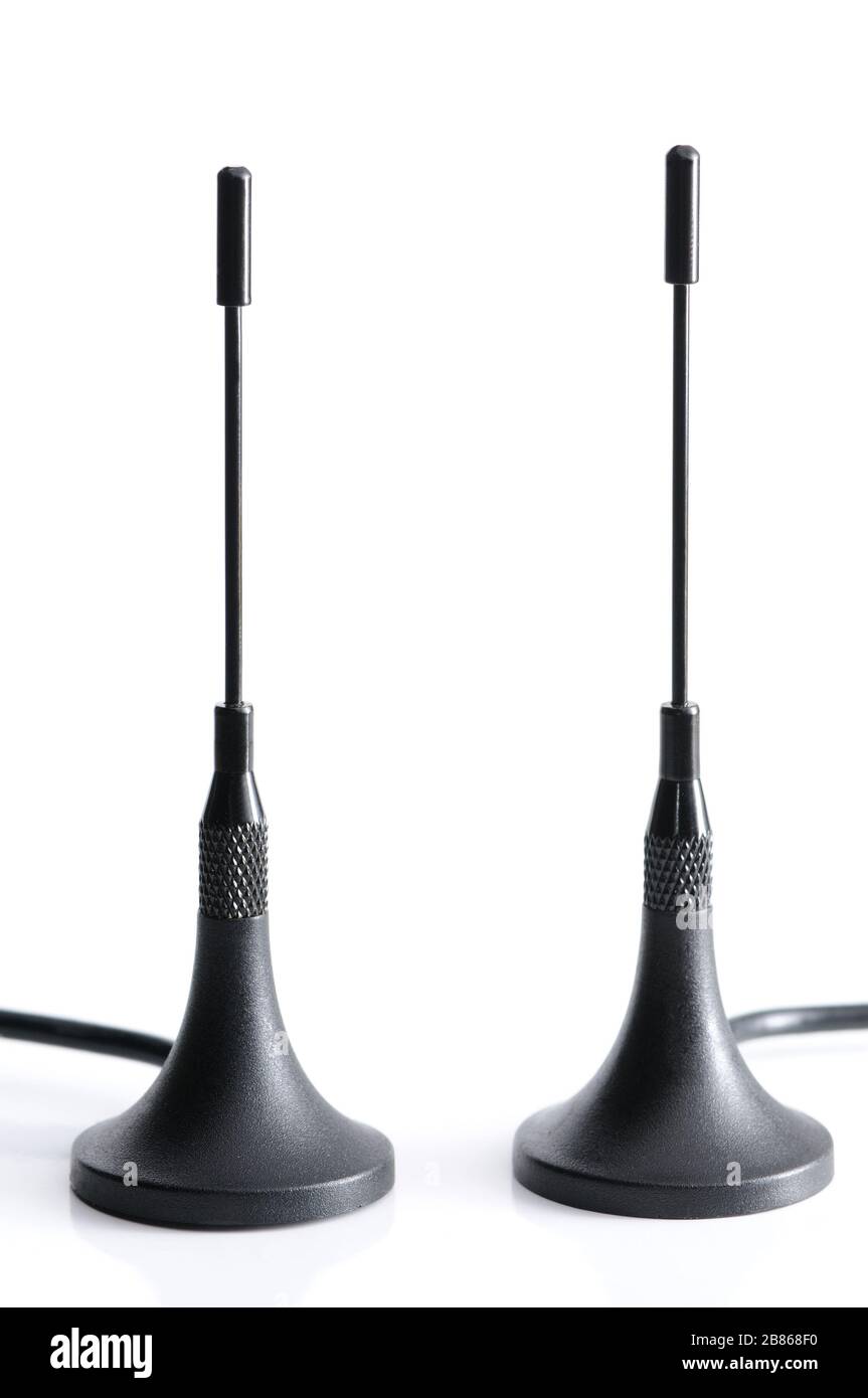 Close-up dark gsm antenna with wires standing on a white table on a ...