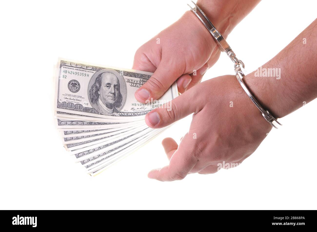Metal handcuffs, hands, and money on white background, conceptual ...