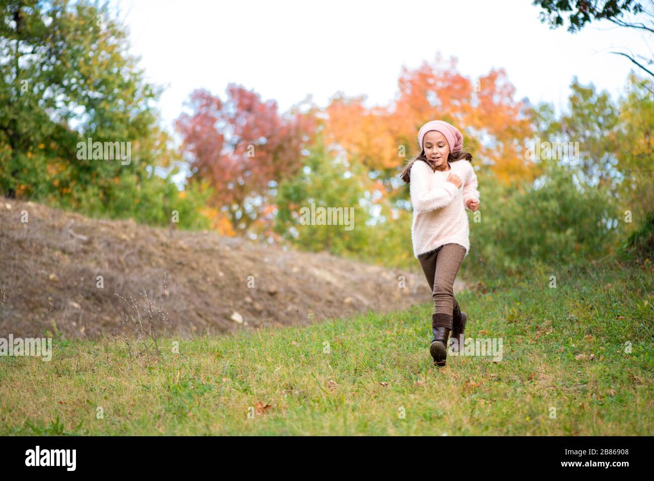 Adorable little girl outdoors at beautiful autumn day running in the ...