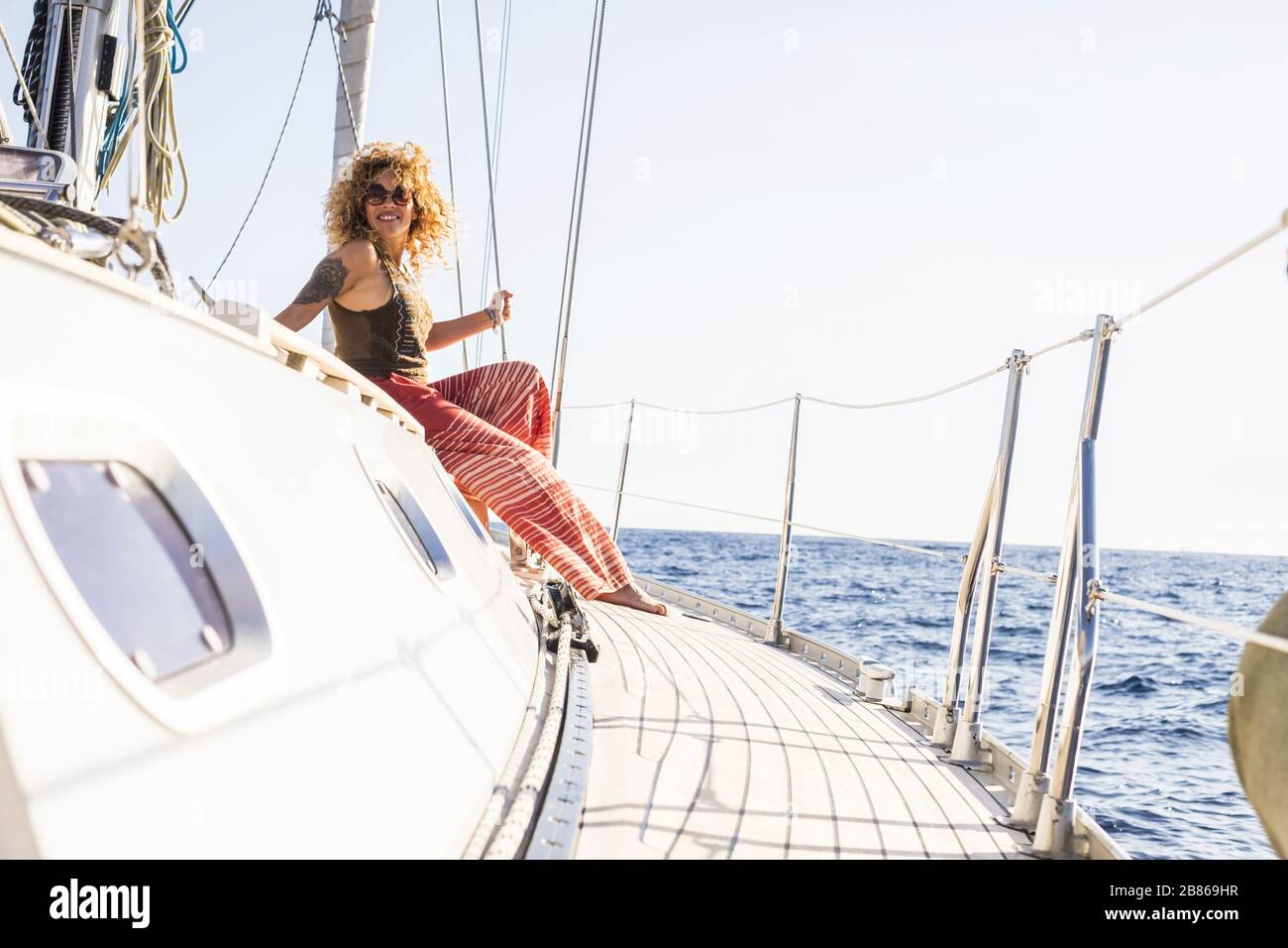 Happy woman enjoy sail boat travel trip sit down on the boat with ocean ...