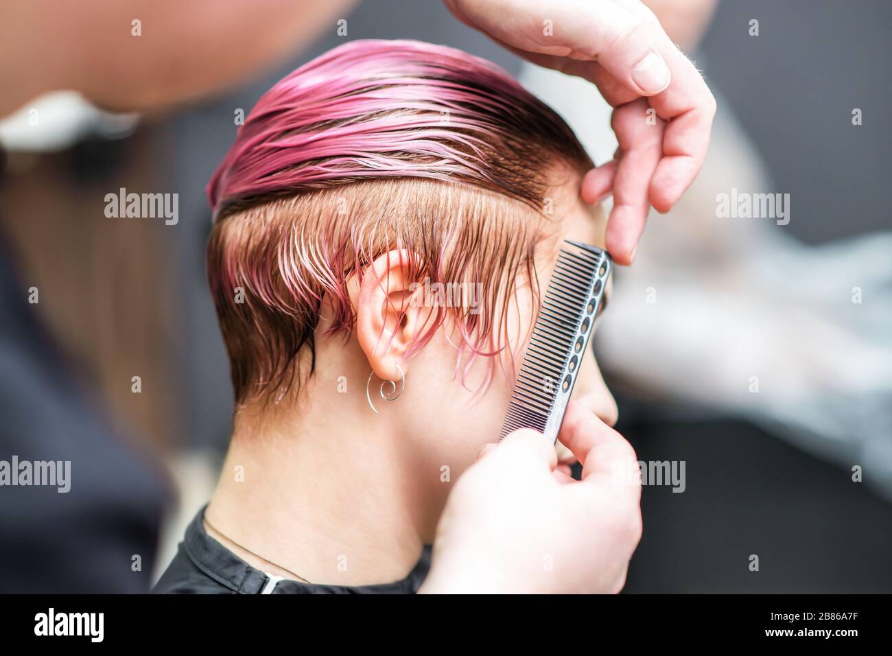 Hairdresser combs hair of woman at hair salon Stock Photo - Alamy