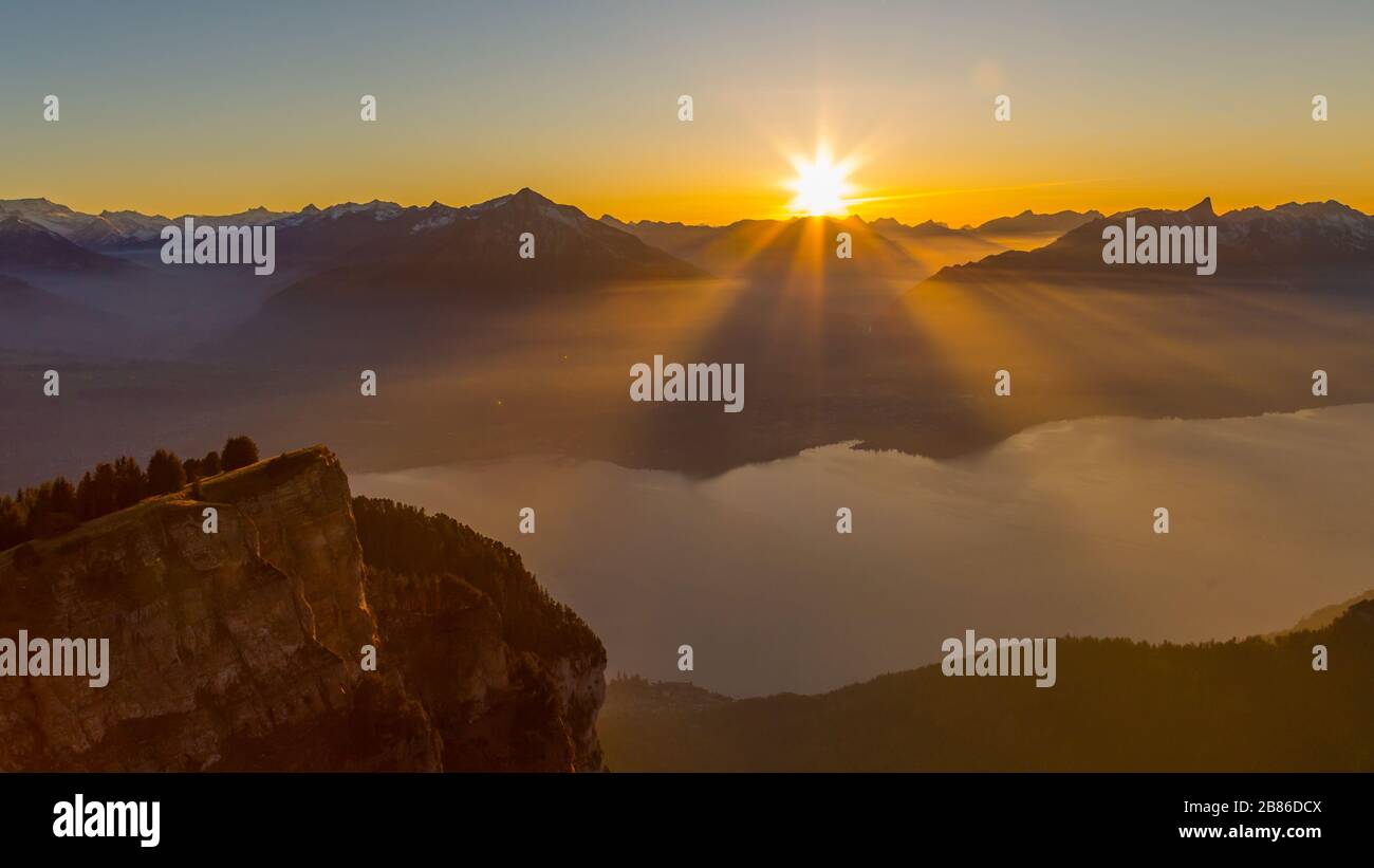 golden sunset over Swiss alpine panorama with lake Thun and mountain ...