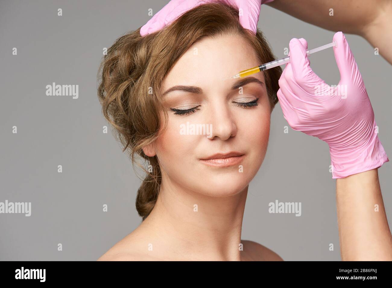 Face needle injection. Young woman cosmetology procedure. Doctor gloves ...