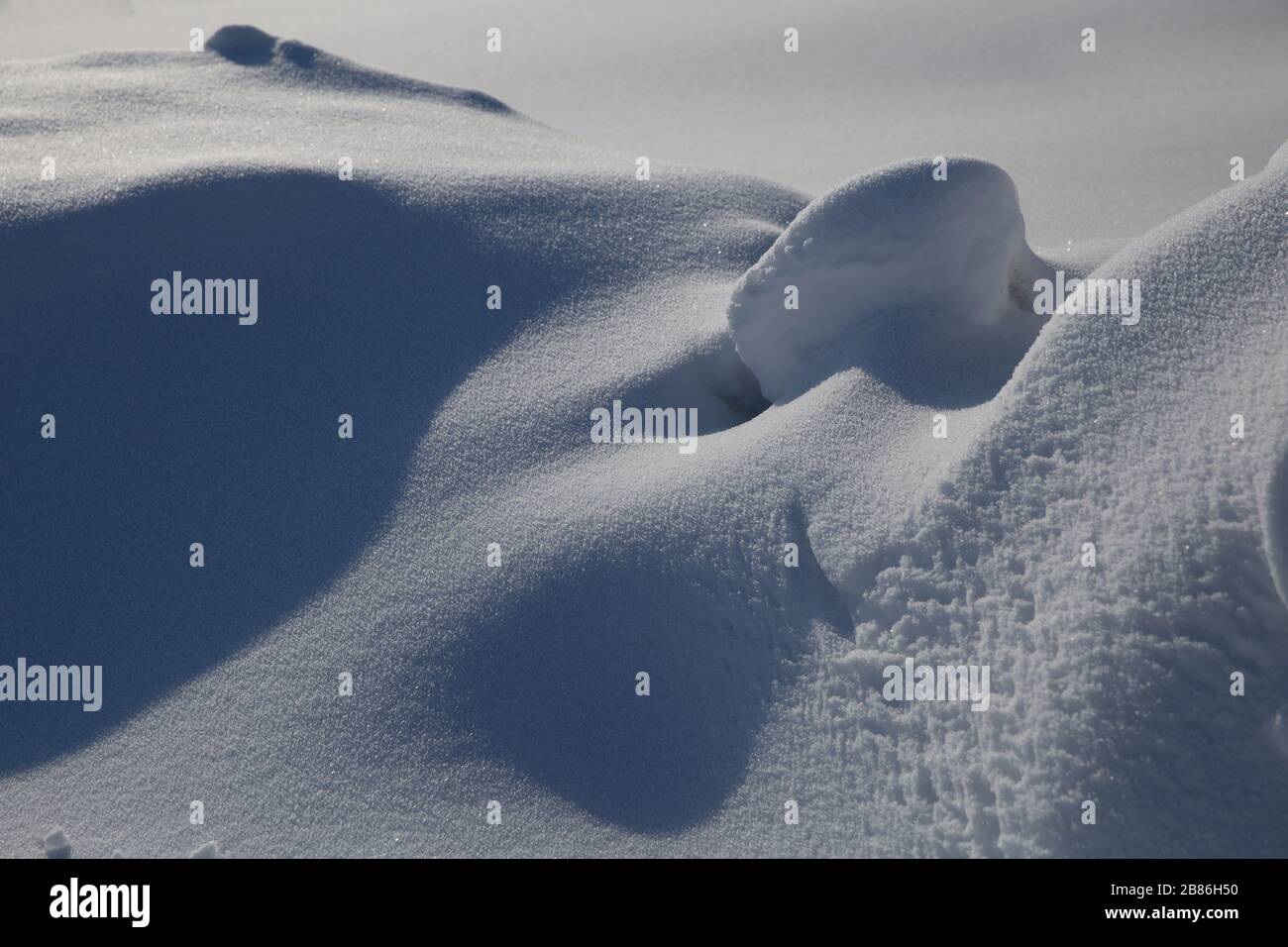 Snowdrift glistens in the sun. Snowdrift silhouettes are similar to a ...