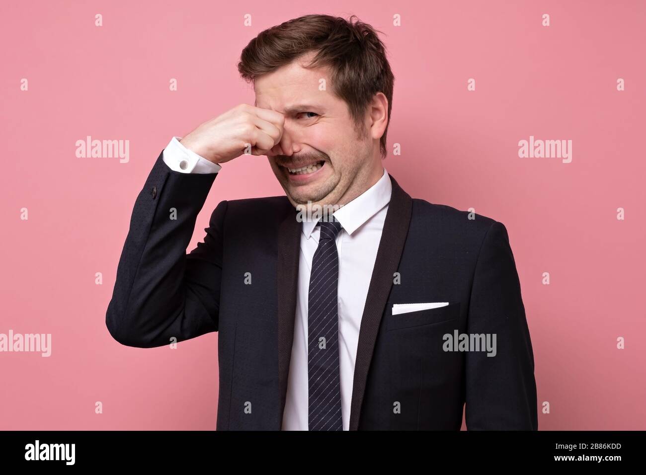 Displeased coworker in suit plugs nose as smells something stink and ...