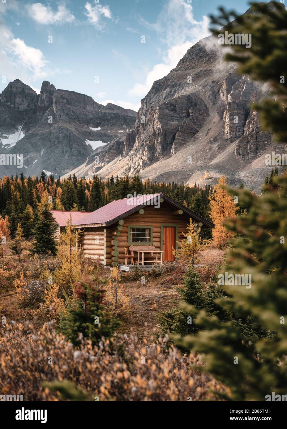 Wooden huts with rocky mountains in autumn forest at Assiniboine ...
