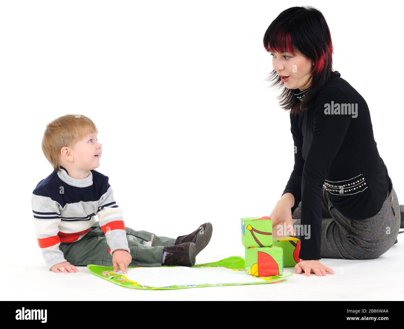 Cute caring young mother is talking with her little unidentified child ...