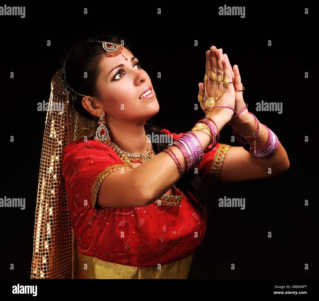 Adorable caucasian white adult woman in indian costume raises hands up ...