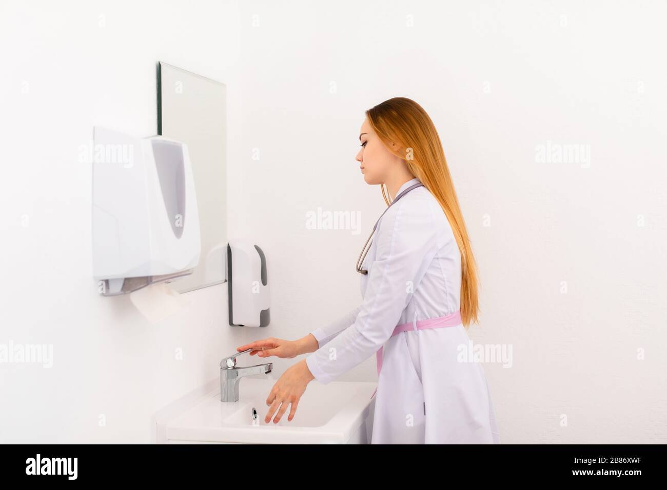 Young female doctor washing her hands befor patient admission in new ...